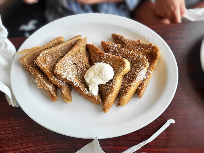 French toast triangles dusted with powdered sugar and topped with a dollop of butter—simple perfection that needs no passport to impress.