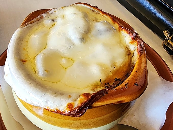 This French onion soup isn't messing around—a molten cheese cap protecting a savory broth below, like delicious lava under a dairy volcano.