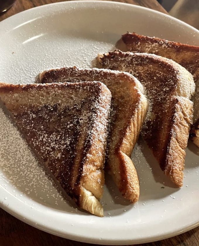 French toast that's achieved that mythical balance—crispy exterior, custardy interior, and a dusting of powdered sugar that would make Scarface jealous.