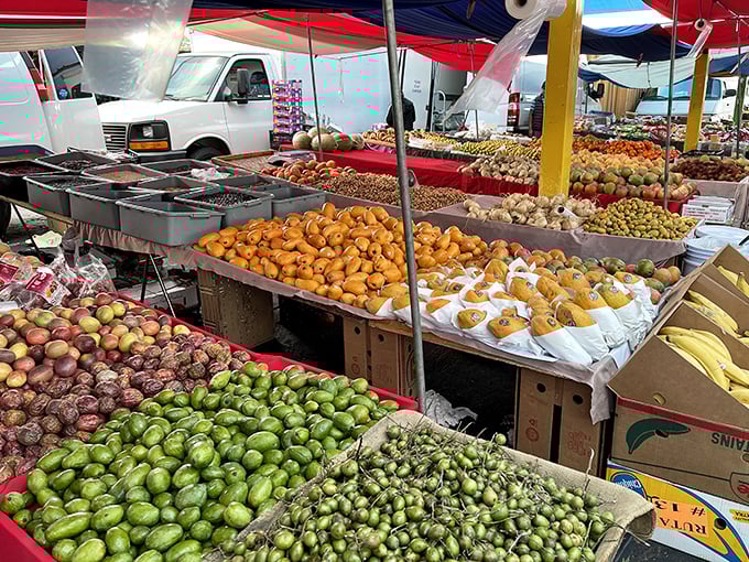 Fresh produce piled high under red canopies proves that healthy eating and bargain hunting aren't mutually exclusive weekend activities.