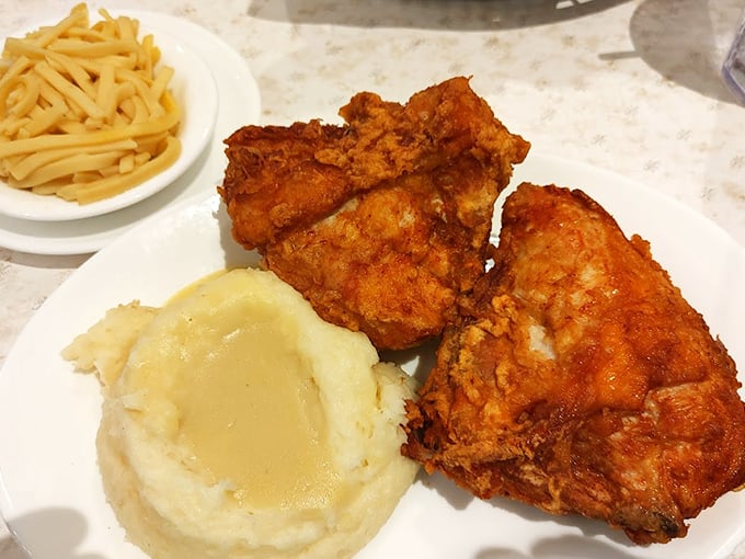 Golden-brown fried chicken with that perfect crackle-when-you-bite-it crust sits beside cloud-like mashed potatoes. Diet plans surrender at the door.