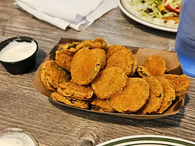 These golden-brown fried pickles aren't just a side dish—they're little discs of tangy, crunchy joy that disappear faster than you can say "more ranch, please."