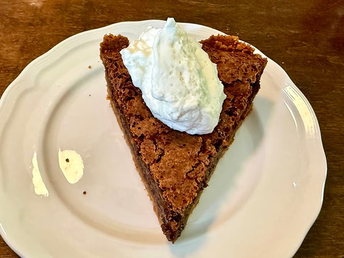 This slice of fudge pie topped with cloud-like whipped cream isn't just dessert—it's the reason buttons were designed to pop.