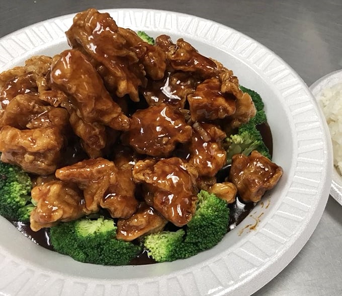 General Tso's Chicken done right – crispy, glossy, and nestled on a bed of vibrant broccoli like edible jewels on a verdant cushion.
