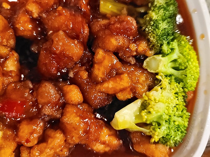 General Tso's chicken glistens with that perfect sticky-sweet sauce, while broccoli stands by as the token vegetable attempting to balance your conscience.
