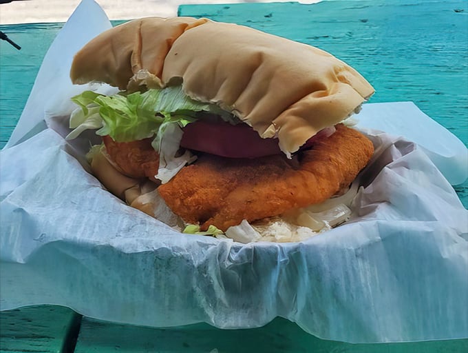 This grouper sandwich refuses to be contained by mere bread – it's making a break for freedom and flavor.