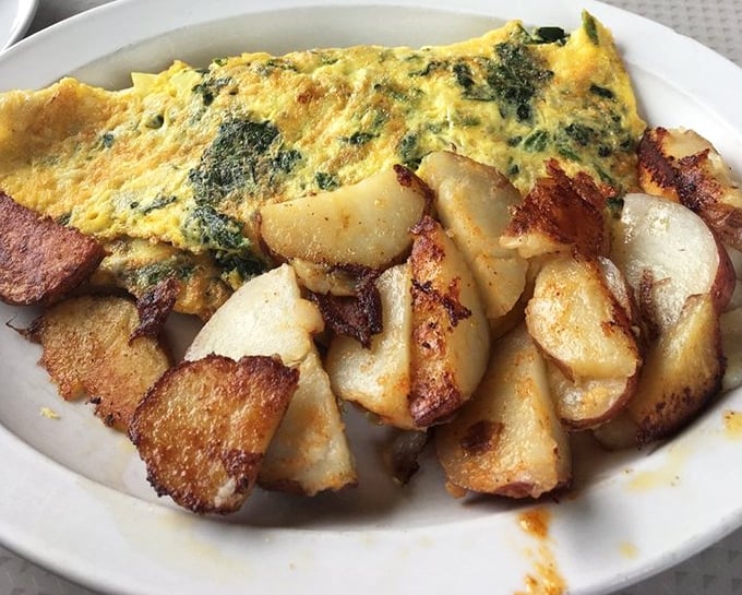 This isn't just an omelet with home fries—it's a masterclass in breakfast architecture where crispy edges meet fluffy interiors in perfect harmony.