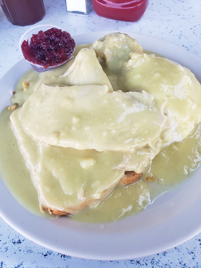The hot turkey sandwich—Thanksgiving's greatest gift to everyday dining—swimming in gravy so good you'll want to request a snorkel with your napkin.