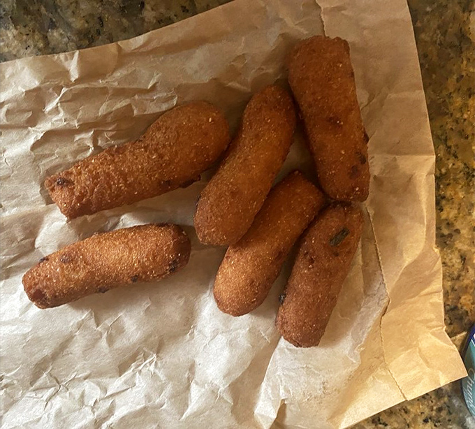 Golden-brown hush puppies that crunch like nature's perfect sound effect. Crispy exterior, steamy cornmeal interior—Southern comfort in bite-sized form.