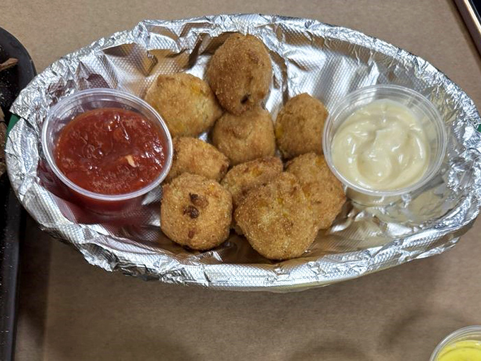 Golden-fried hush puppies with dipping sauces—the perfect supporting actors in your crab feast drama. Crispy outside, tender inside, completely irresistible.