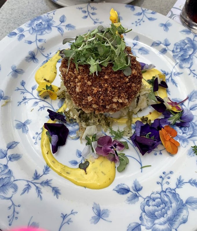 This isn't just any crab cake—it's edible art, where crispy exterior gives way to delicate seafood, all dressed up with edible flowers like it's heading to the Royal Ascot.