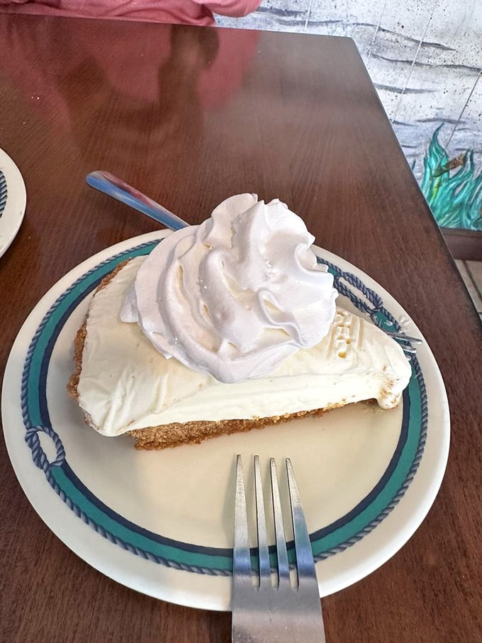 That key lime pie towers like a fluffy cloud of citrus heaven, the perfect sweet ending to your seafood adventure.