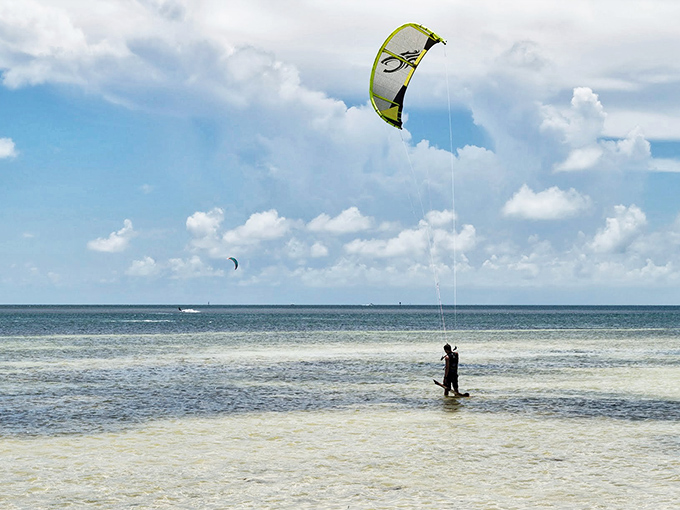 Kiteboarding at Anne's Beach: where humans temporarily achieve flight without TSA pat-downs or baggage fees.