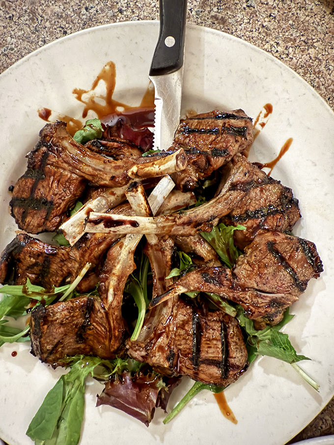 These lamb chops aren't just grilled, they're transformed—a carnivore's dream resting on a bed of greens like meaty royalty.