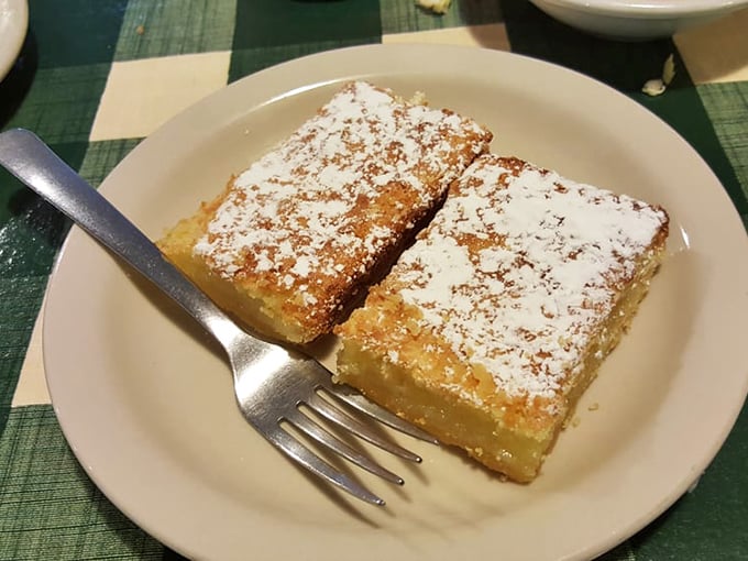 Lemon bars dusted with powdered sugar—bright, tangy squares of sunshine that provide the perfect sweet counterpoint to a savory deli feast.