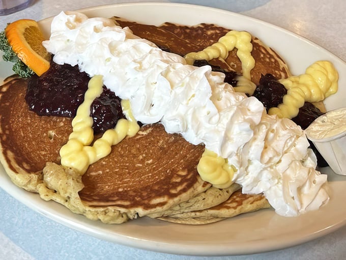 This isn't just a stack of pancakes—it's a mountain of joy topped with whipped cream, blueberry compote, and enough happiness to fuel your entire day.