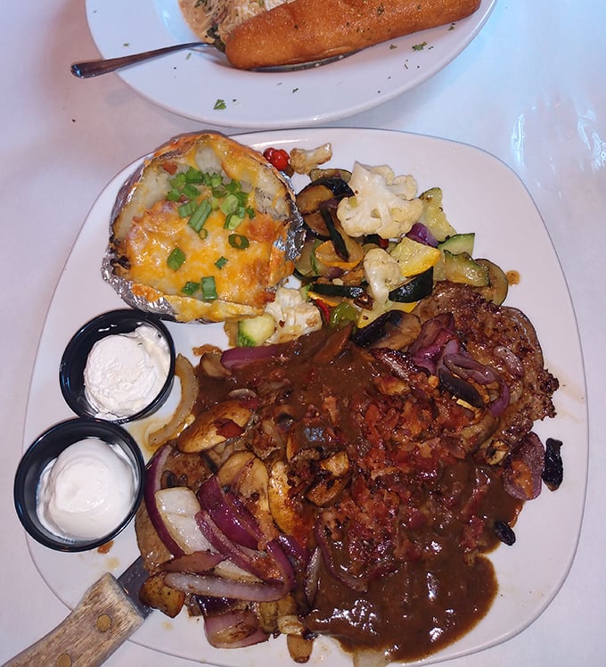 A loaded baked potato steals the spotlight from this hearty steak smothered in mushroom gravy – supporting actors deserve Oscars too!