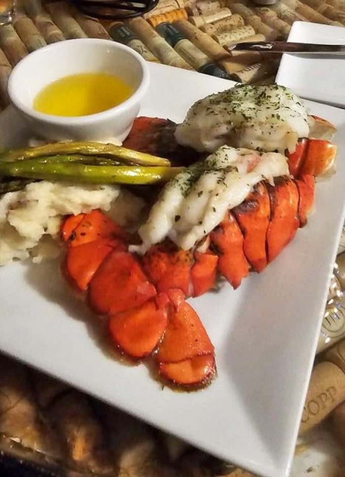 This lobster tail isn't just dinner – it's maritime royalty dressed in butter and herbs, flanked by asparagus soldiers standing at attention.