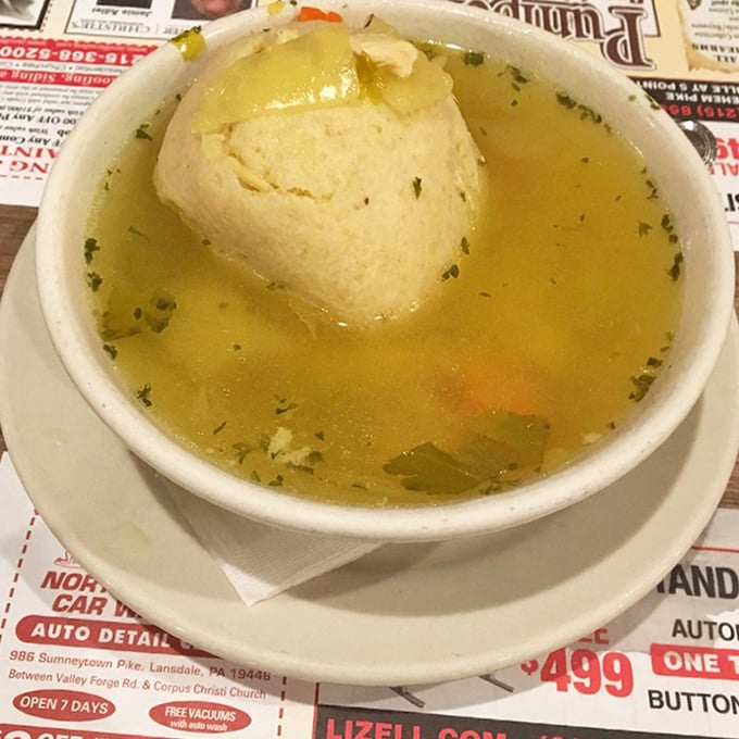 The matzo ball soup—a golden pool of comfort cradling a fluffy dumpling that would make any grandmother nod in approval.