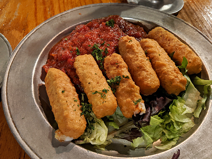 Mozzarella sticks with attitude—crispy, golden soldiers standing at attention on a bed of greens, ready to dive into that marinara battlefield.