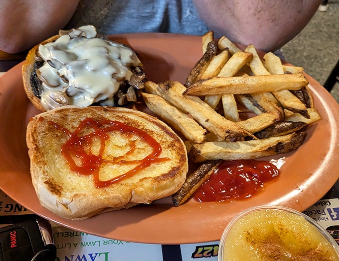 The mushroom Swiss burger arrives like a savory still life—golden fries standing at attention beside their beefy commander. Ketchup art included at no extra charge.