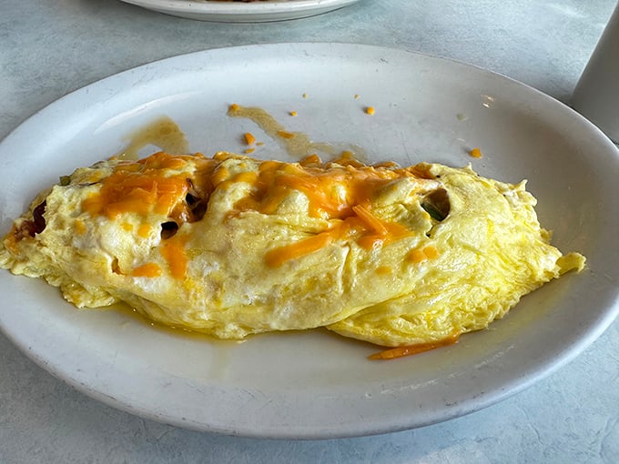 Behold the humble omelet, elevated to art form – fluffy eggs embracing melted cheese in a relationship more perfect than Danny and Sandy in "Grease."