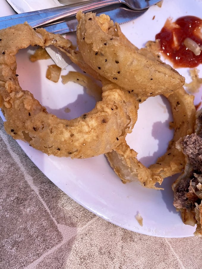 These onion rings aren't just fried—they're golden halos of crunch that make you wonder why vegetables ever bothered growing any other way.