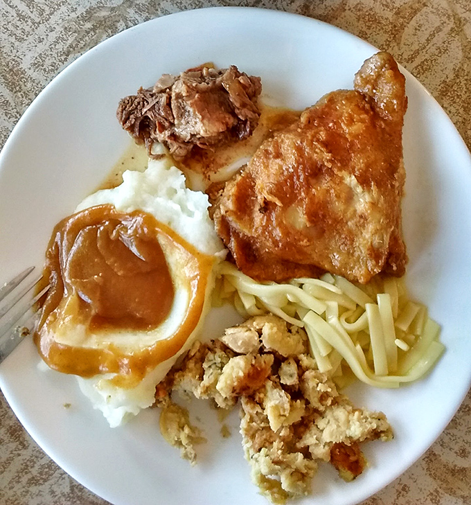 This isn't just fried chicken – it's a masterclass in comfort cuisine, resting atop a bed of noodles with gravy that could make a vegetarian question their life choices.