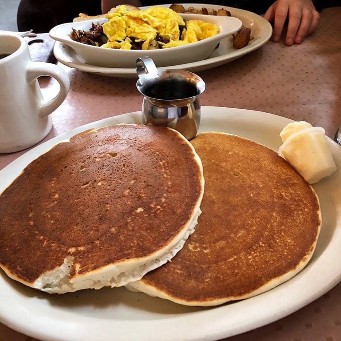 These pancakes arrive looking like edible frisbees, golden-brown and ready to soak up every drop of maple syrup.