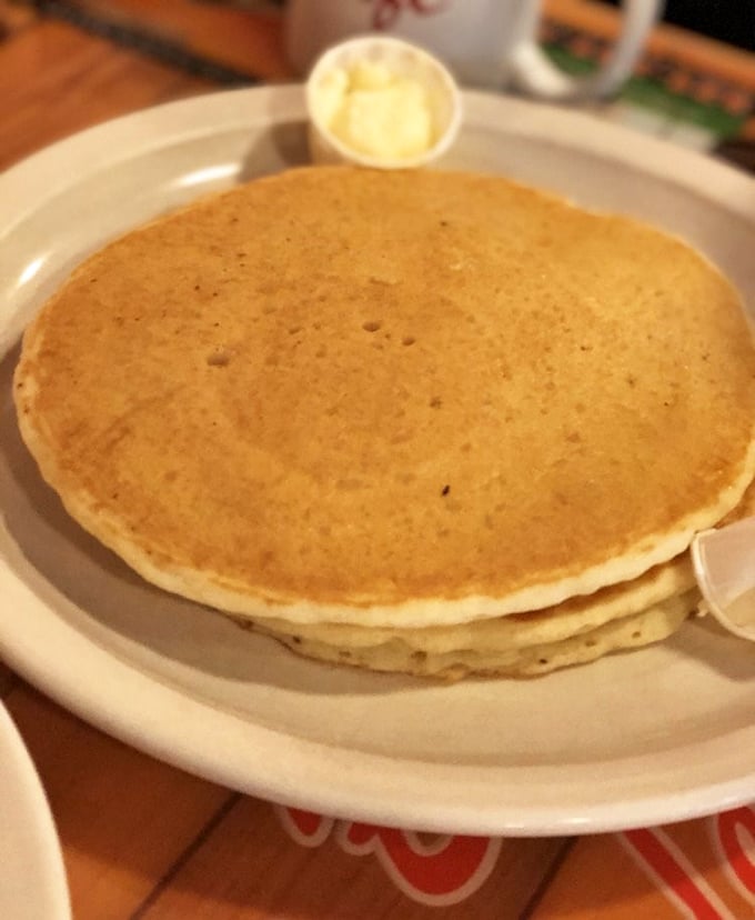 These pancakes aren't just breakfast, they're edible sunshine—perfectly golden discs stacked high, awaiting their maple syrup baptism.
