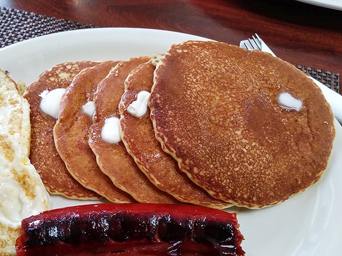 Five perfect pancakes stacked like edible architecture, each one a fluffy testament to the power of proper breakfast food.