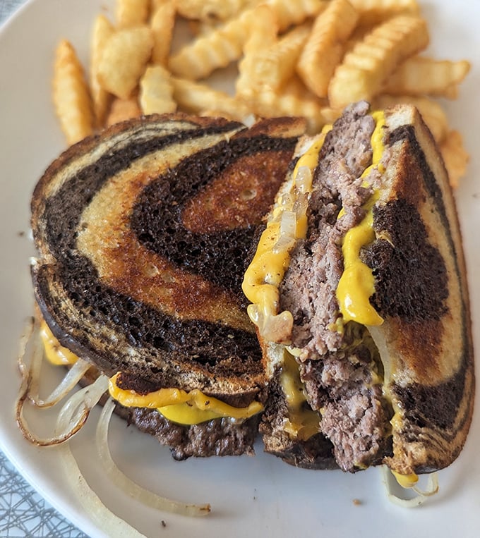 The patty melt—that perfect marriage of beef, cheese, and grilled marble rye—served with crispy fries that somehow manage to stay crispy until the last bite.
