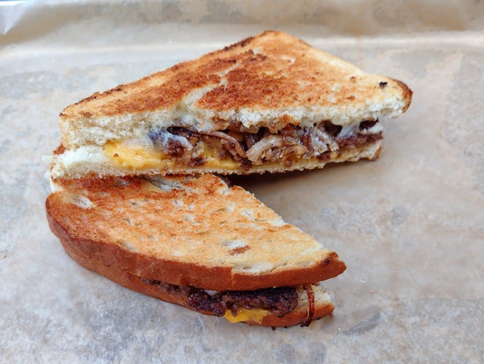 The Patty Melt—where grilled sourdough, melted cheese, and caramelized onions form a holy trinity around a perfectly smashed beef patty.