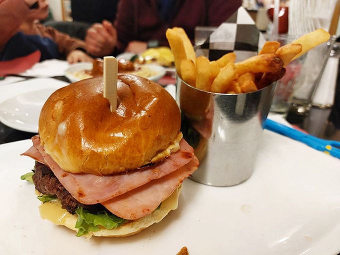 This isn't just a burger—it's an architectural achievement, where layers of ham, cheese, and beef create a skyscraper of flavor that demands both hands and several napkins.