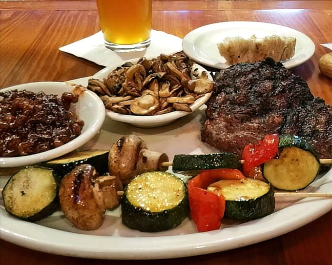 A plate that tells a story of perfect balance: juicy steak, sautéed mushrooms, grilled vegetables, and is that a beer I spot? The four food groups of happiness.