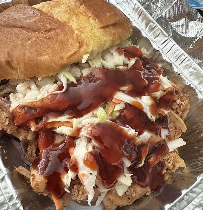 This isn't just a sandwich—it's an architectural masterpiece of pulled chicken, slaw, and sauce that requires both hands and several napkins.
