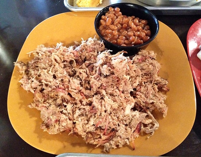 Pulled pork that practically shreds itself, accompanied by baked beans that clearly didn't come from any can. This is what comfort looks like on a plate.