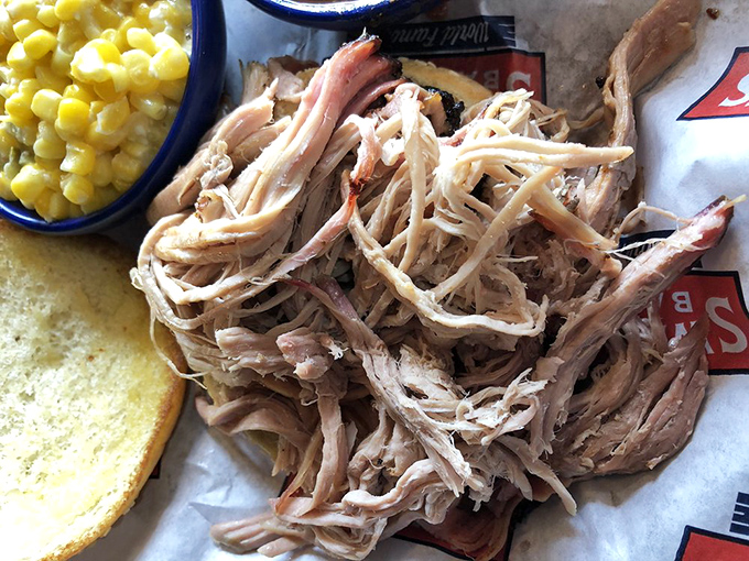 Pulled pork so tender it practically surrendered to gravity, served with sweet corn and Texas toast—a plate that speaks fluent comfort food.