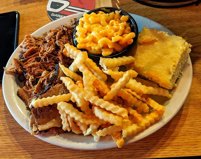 A plate that doesn't need fancy garnishes – just pulled pork, mac and cheese, fries, and cornbread forming the Mount Rushmore of barbecue satisfaction.