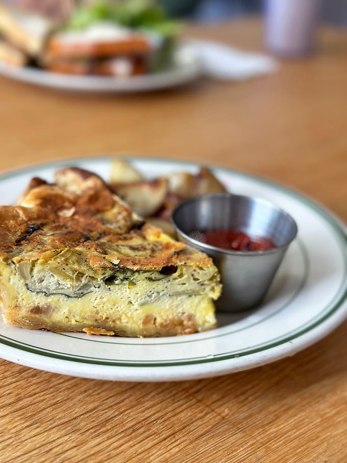 This quiche doesn't mess around—golden crust, perfectly set filling, and a side of potatoes. Breakfast of champions, or anyone with taste buds.