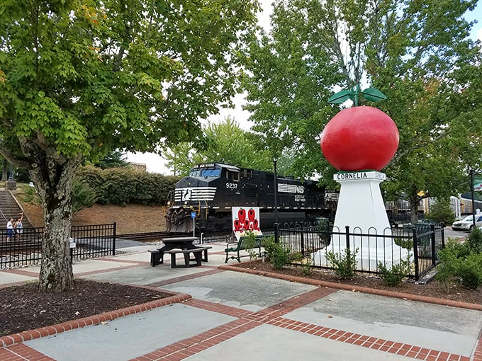 The perfect juxtaposition: a bright red apple monument with a Norfolk Southern train cruising by—two icons of Cornelia's heritage sharing the spotlight.
