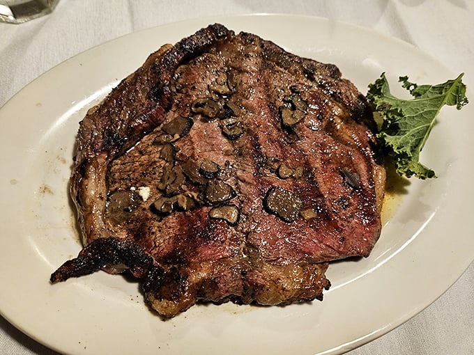 The ribeye arrives like a masterpiece on a canvas of white porcelain—a beautiful relationship between fire, seasoning, and exceptional beef.