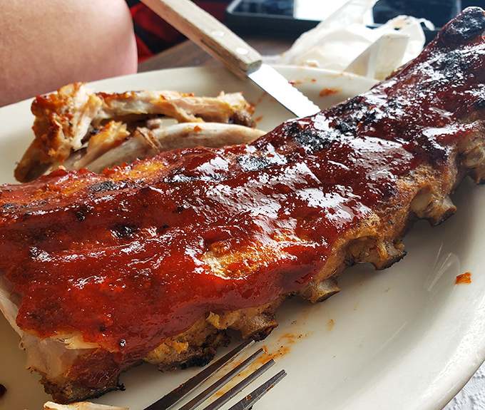 These ribs don't just fall off the bone—they practically leap into your mouth. The glossy BBQ sauce is the kind that justifies keeping a backup shirt in the car.