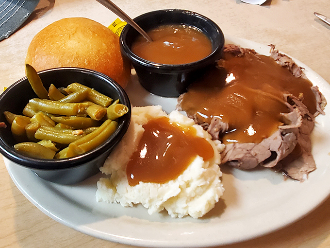 Roast beef done right – tender slices bathed in rich gravy alongside green beans and mashed potatoes. Grandma would approve, then ask for seconds.