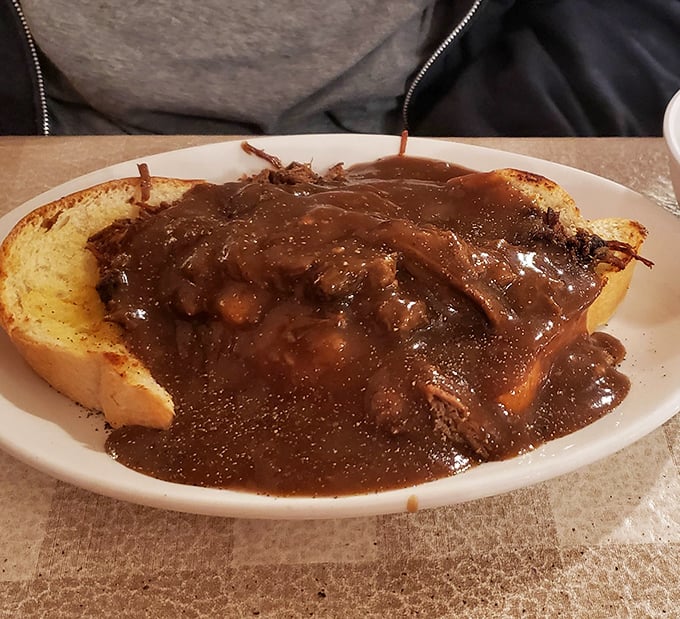Texas toast supporting a mountain of slow-cooked beef, swimming in rich gravy—this isn't just a meal, it's an edible hug.