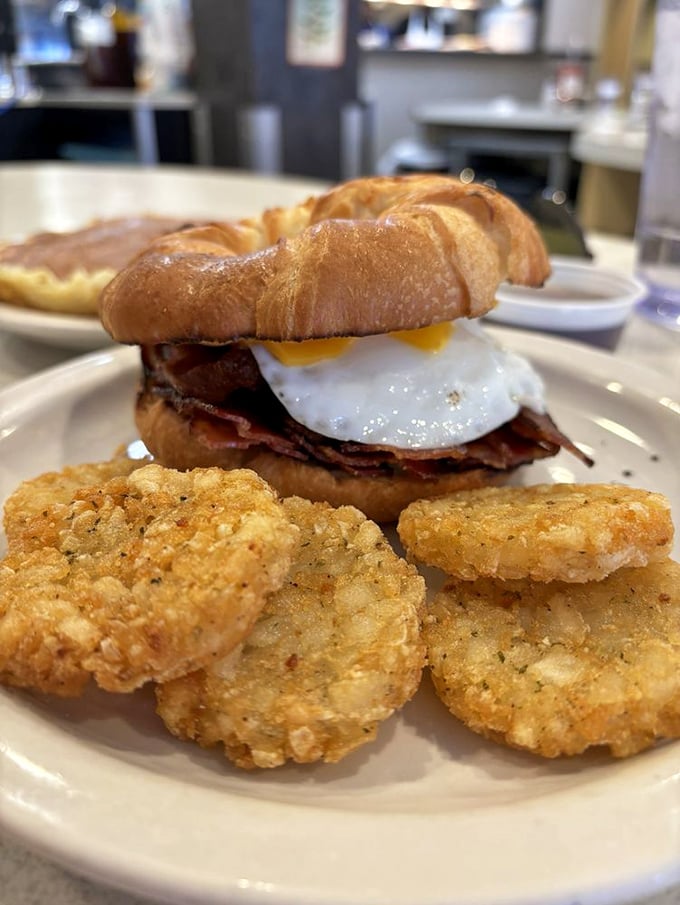 This breakfast sandwich isn't messing around—crispy bacon, golden egg, and a croissant that would make a French baker weep.