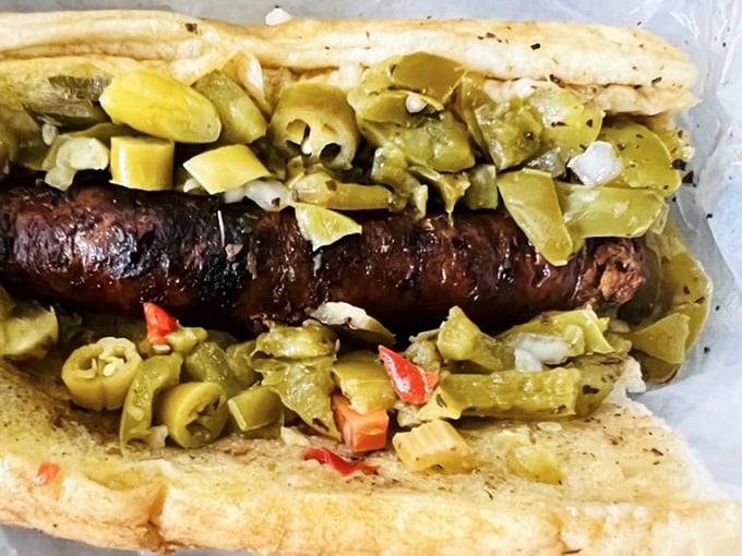 The charcoal-grilled Italian sausage, nestled in its bread cradle and crowned with peppers. It's like a flavor explosion waiting for permission to detonate.
