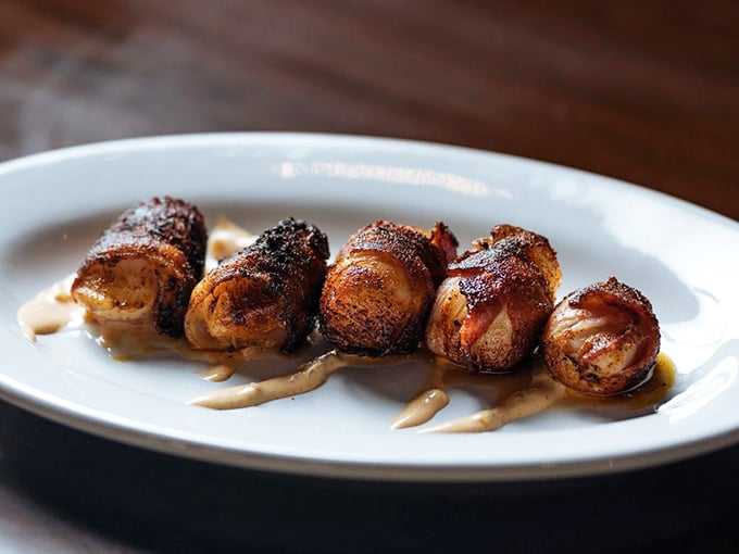 Bacon-wrapped scallops glistening with caramelization – proof that sometimes the simplest preparations yield the most profound flavors.