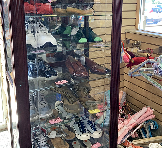 A United Nations of footwear, where wingtips and sneakers coexist peacefully in their glass display case.