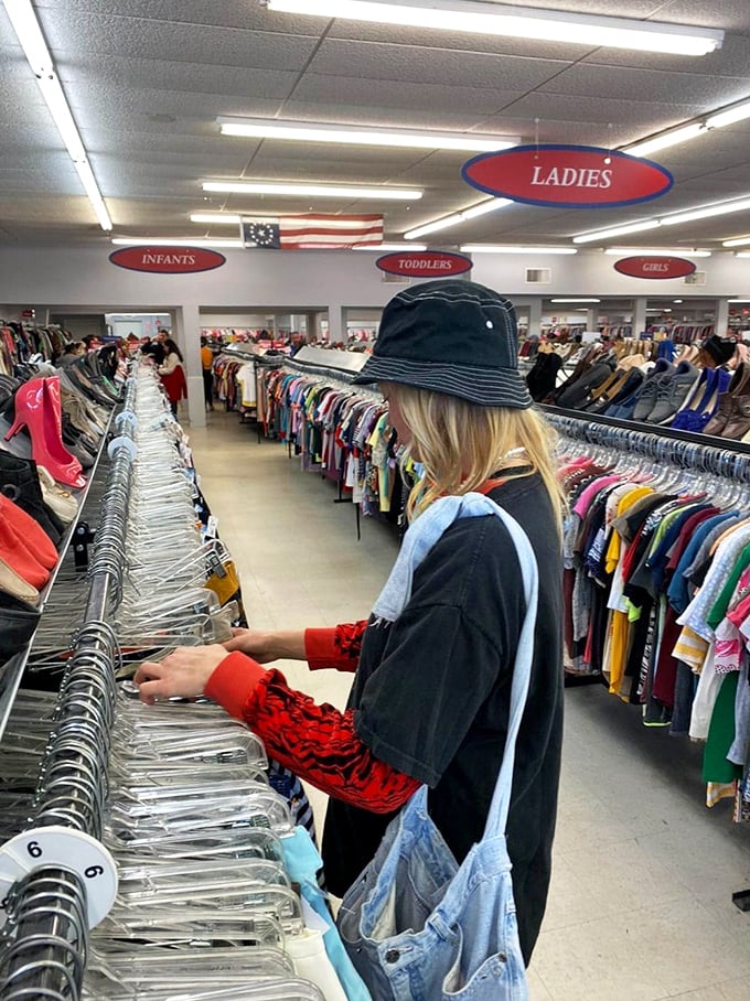 A shopper navigates the carefully organized racks, hunting for that perfect piece—thrifting is part skill, part meditation, all adventure.
